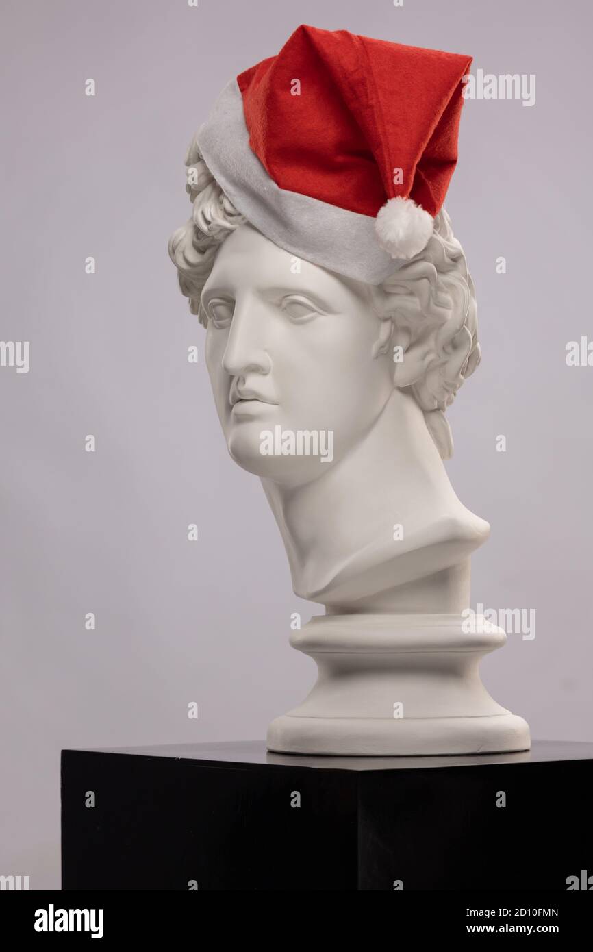 White Plaster Statue of Apollo Belvedere in a red cap of Santa Claus ...