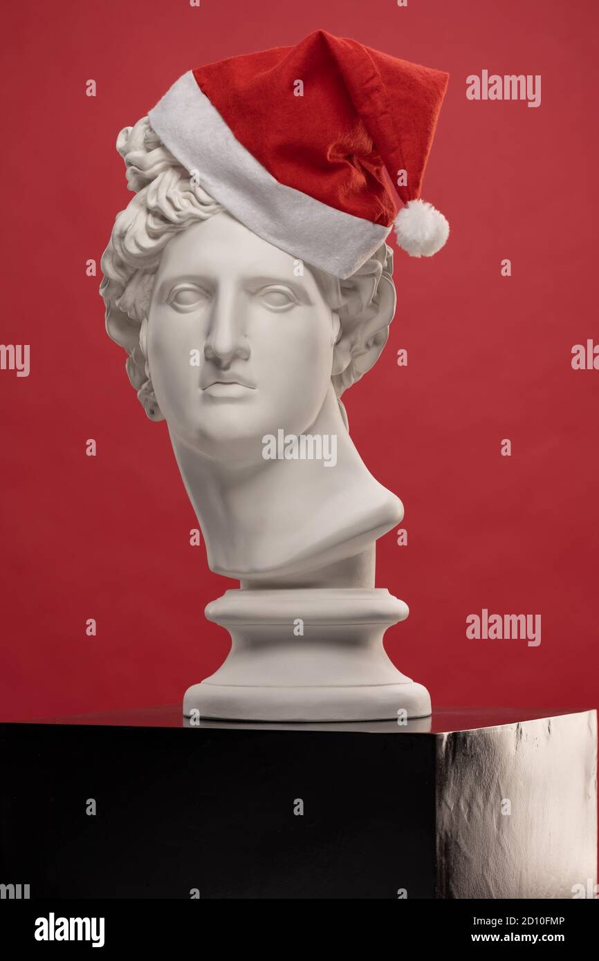 White Plaster Statue of Apollo Belvedere in a red cap of Santa Claus ...