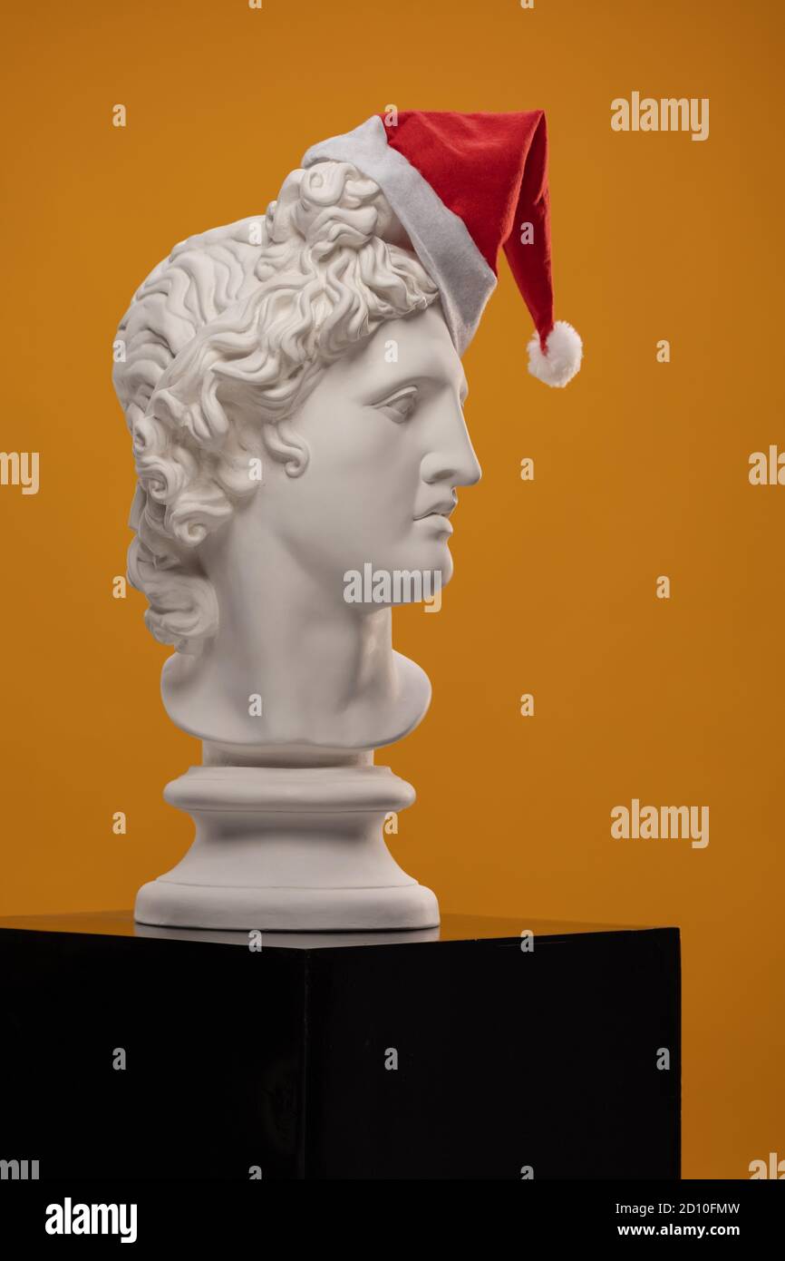 White Plaster Statue of Apollo Belvedere in a red cap of Santa Claus ...