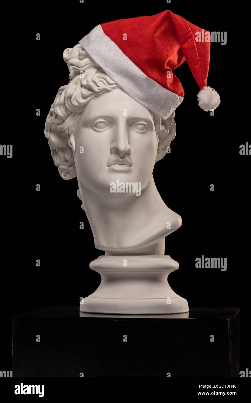 White Plaster Statue of Apollo Belvedere in a red cap of Santa Claus ...