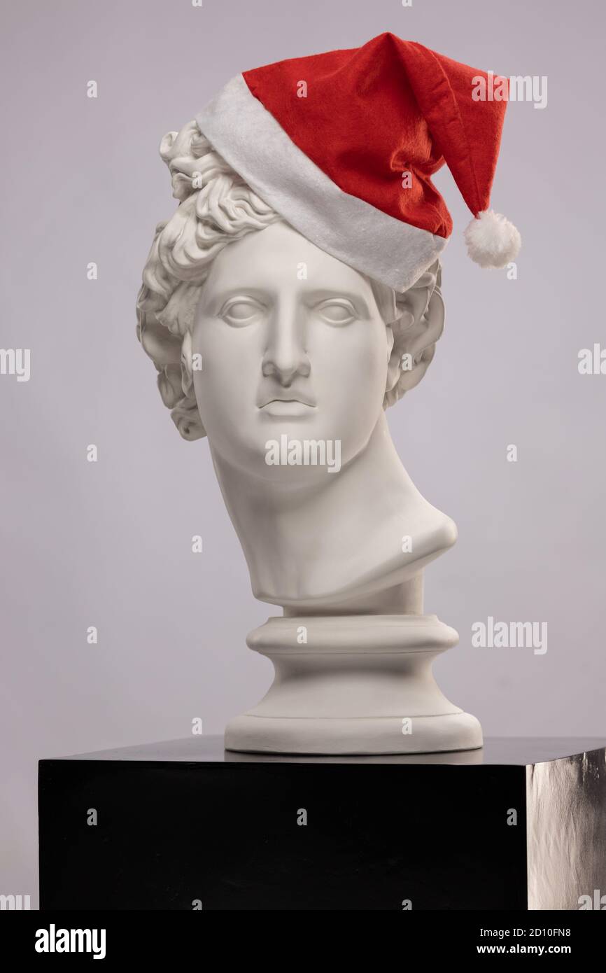 White Plaster Statue of Apollo Belvedere in a red cap of Santa Claus ...