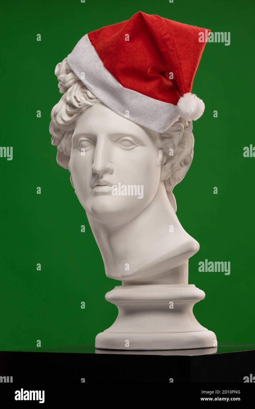 White Plaster Statue of Apollo Belvedere in a red cap of Santa Claus ...
