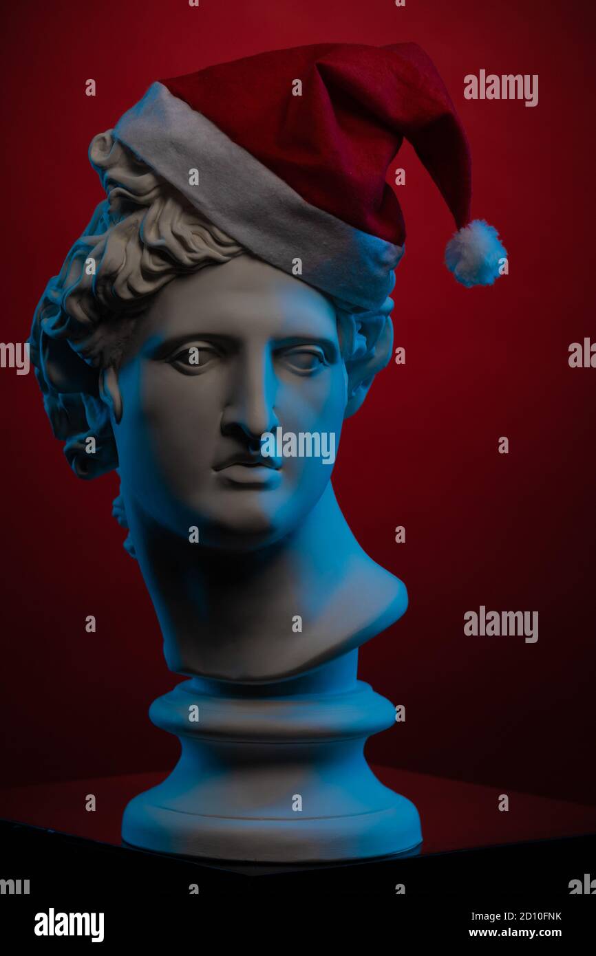 White gypsum Statue of Apollo Belvedere in a red cap of Santa Claus in ...