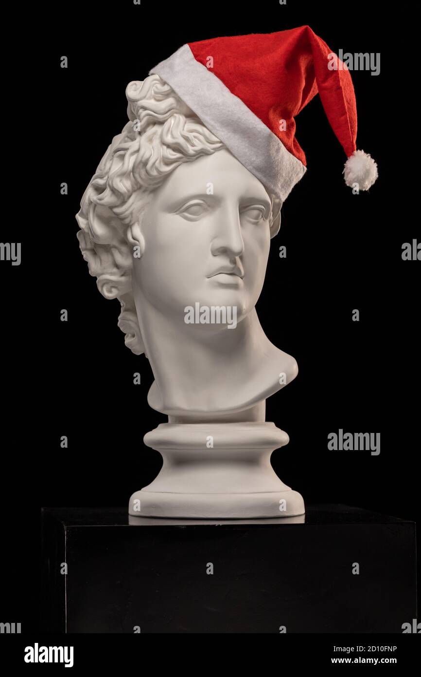 White Plaster Statue of Apollo Belvedere in a red cap of Santa Claus ...