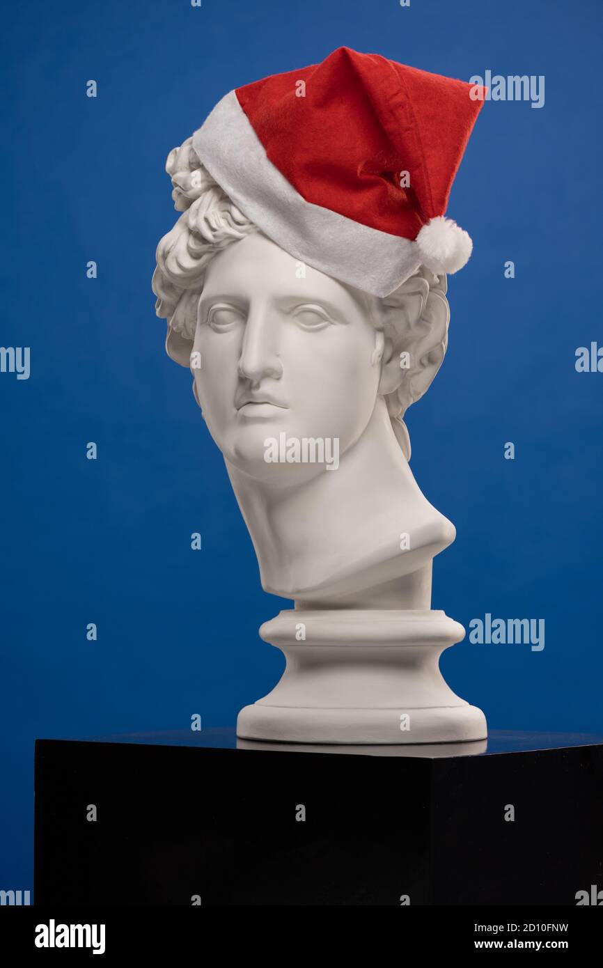 White Plaster Statue of Apollo Belvedere in a red cap of Santa Claus ...