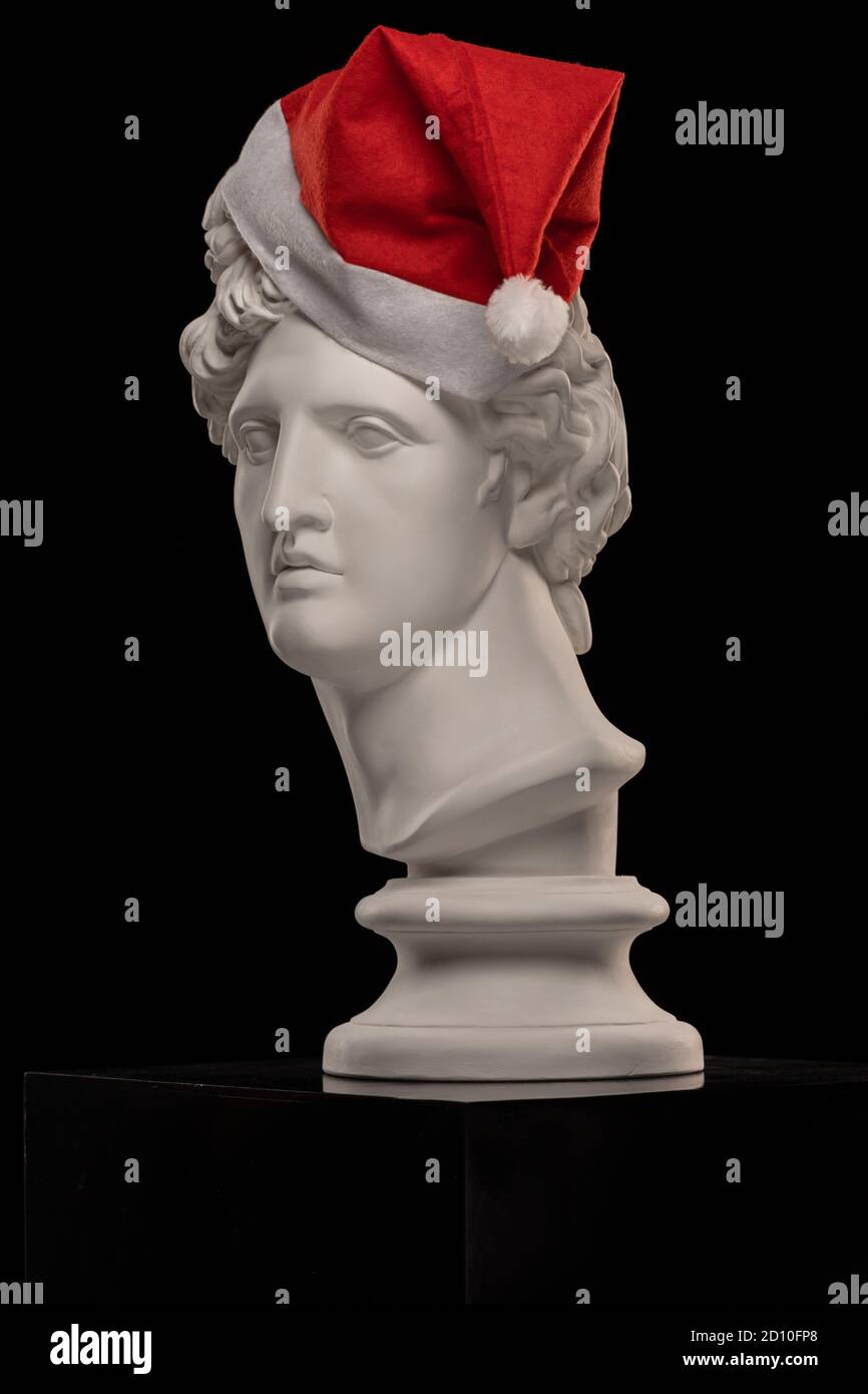 White Plaster Statue of Apollo Belvedere in a red cap of Santa Claus ...