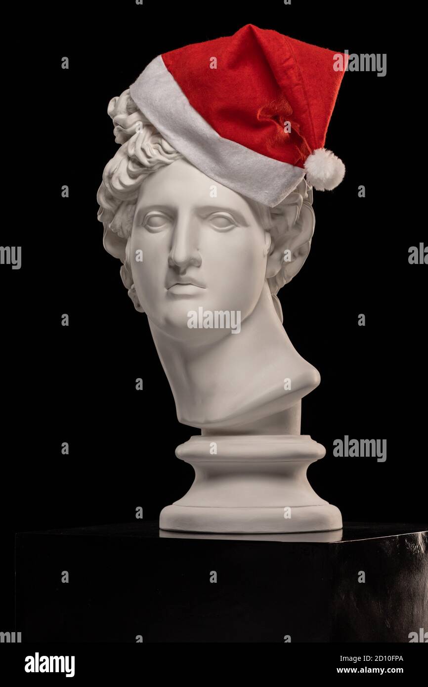 White Plaster Statue of Apollo Belvedere in a red cap of Santa Claus ...