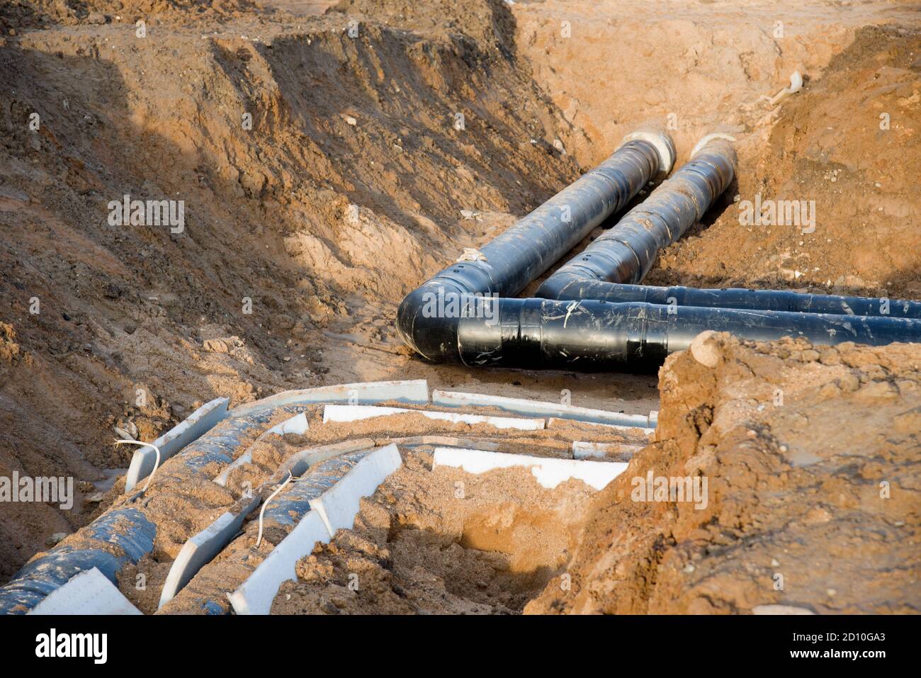 Laying of underground storm sewer pipes in ditch. Installation of water ...