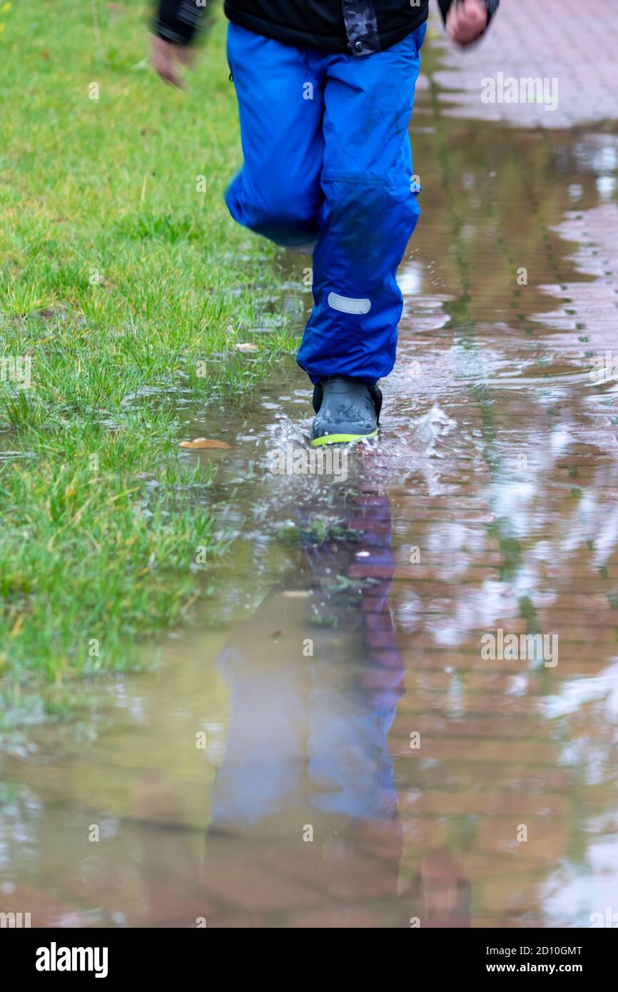 Child splash puddles boots hi-res stock photography and images - Alamy