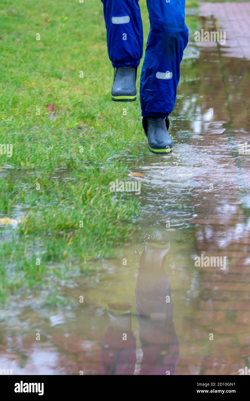 Kid child jumping puddle water splash hi-res stock photography and ...