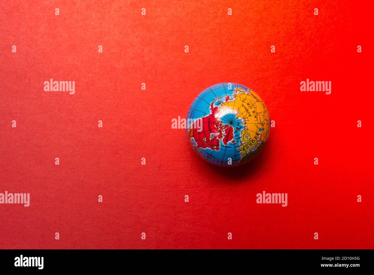 Top view of a small globe isolated on a red background Stock Photo - Alamy