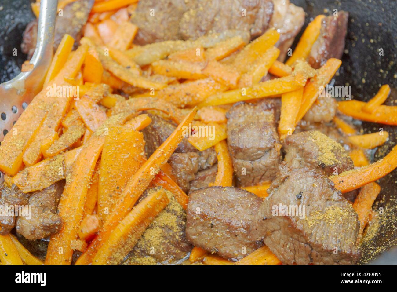 Cooking pilaf in a cauldron on the grill outside in the summer Stock ...