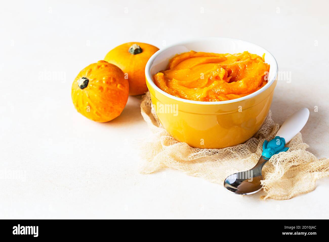 Homemade pumpkin puree in bowl with baby spoon and fresh pumpkins on ...