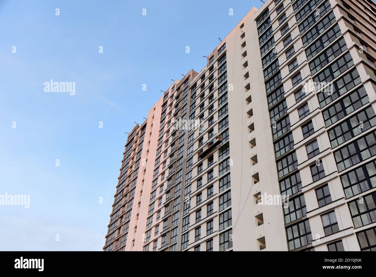 Suspended cradle on the facade of the skyscraper. Mobile scaffolding ...