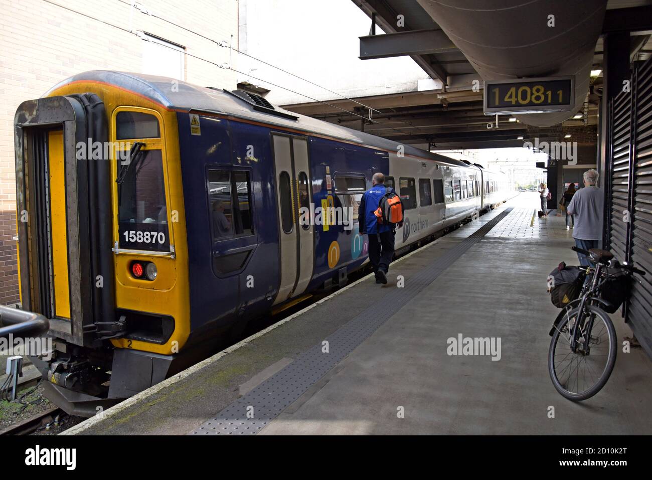 A Northern trains driver walks along the platform to his class 158 ...