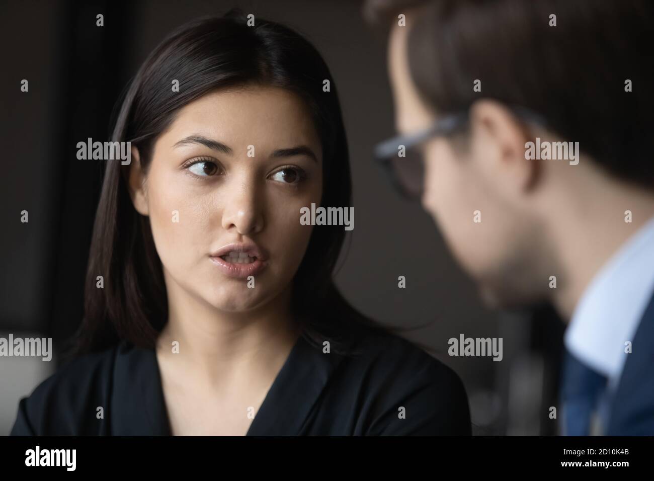 Serious young indian ethnicity businesswoman talking to male confident ...