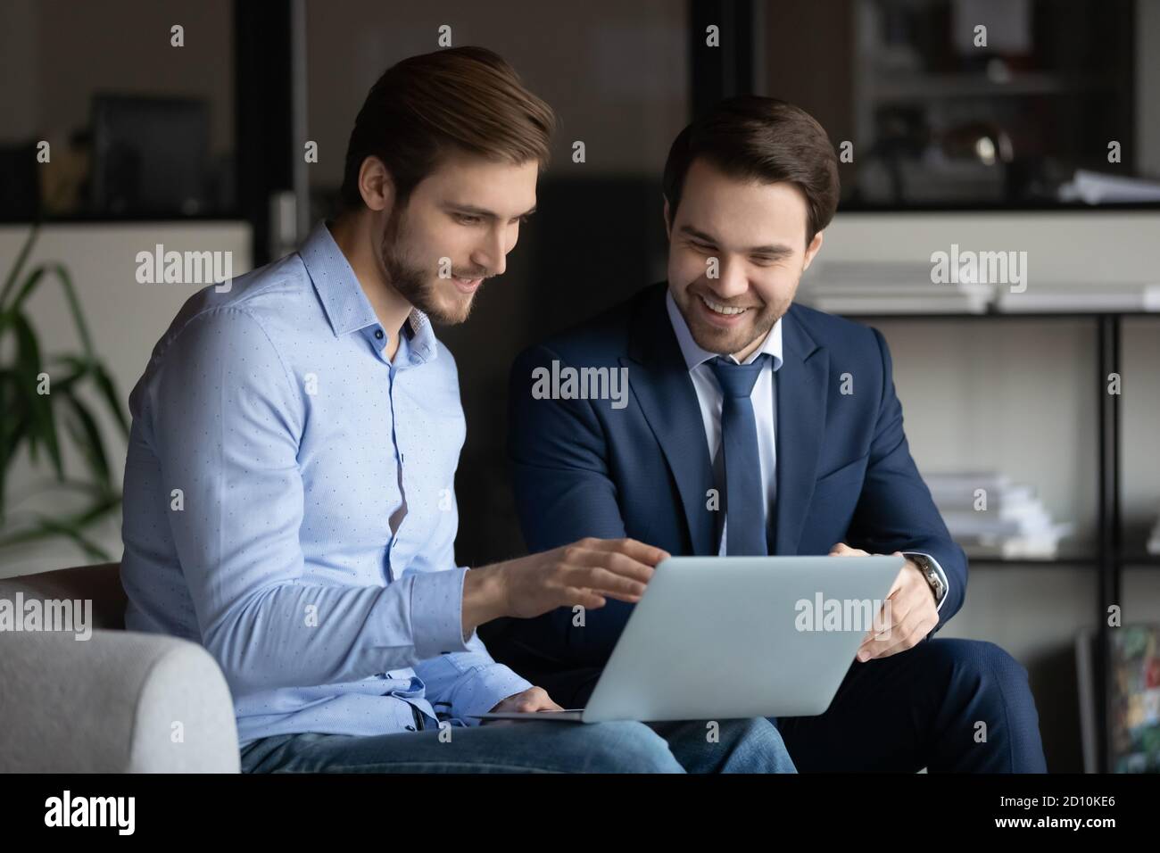 Two smiling businessmen discussing good project results Stock Photo - Alamy