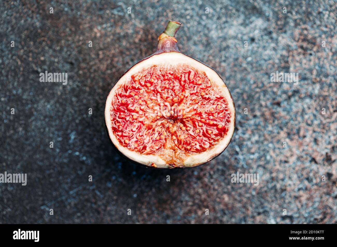Macro photography of a fresh ripe cutted fig on the textured background ...