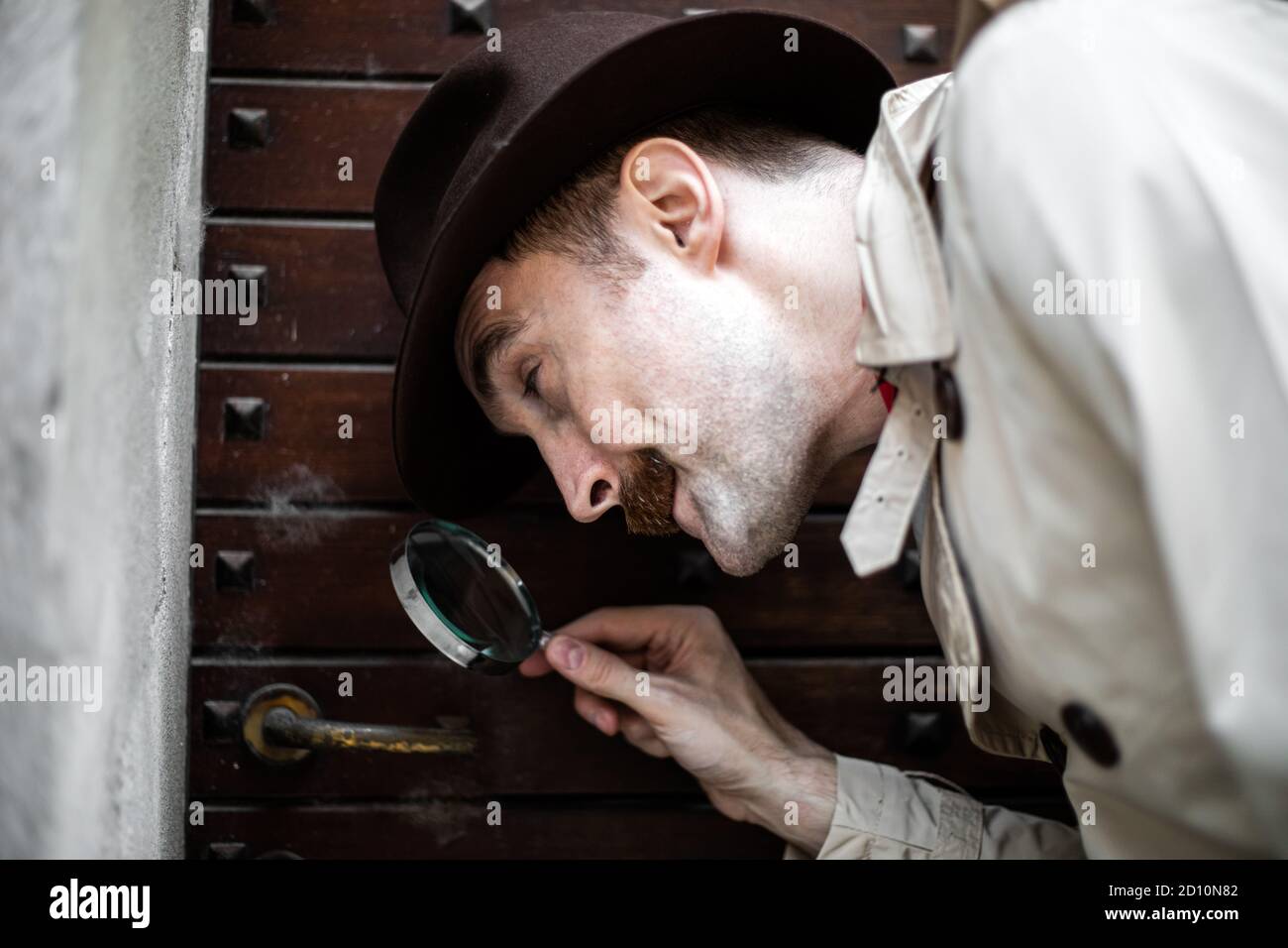 Detective using a magnify lens Stock Photo - Alamy