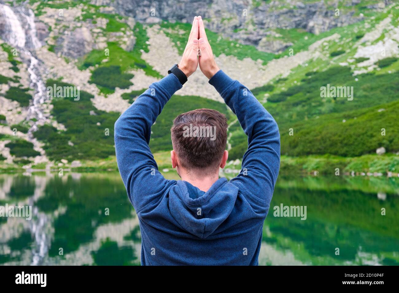 Young standing in yoga pose with amazing view on the waterfall and ...