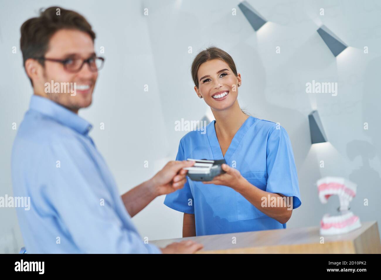 Patient paying for dental visit in clinic Stock Photo - Alamy