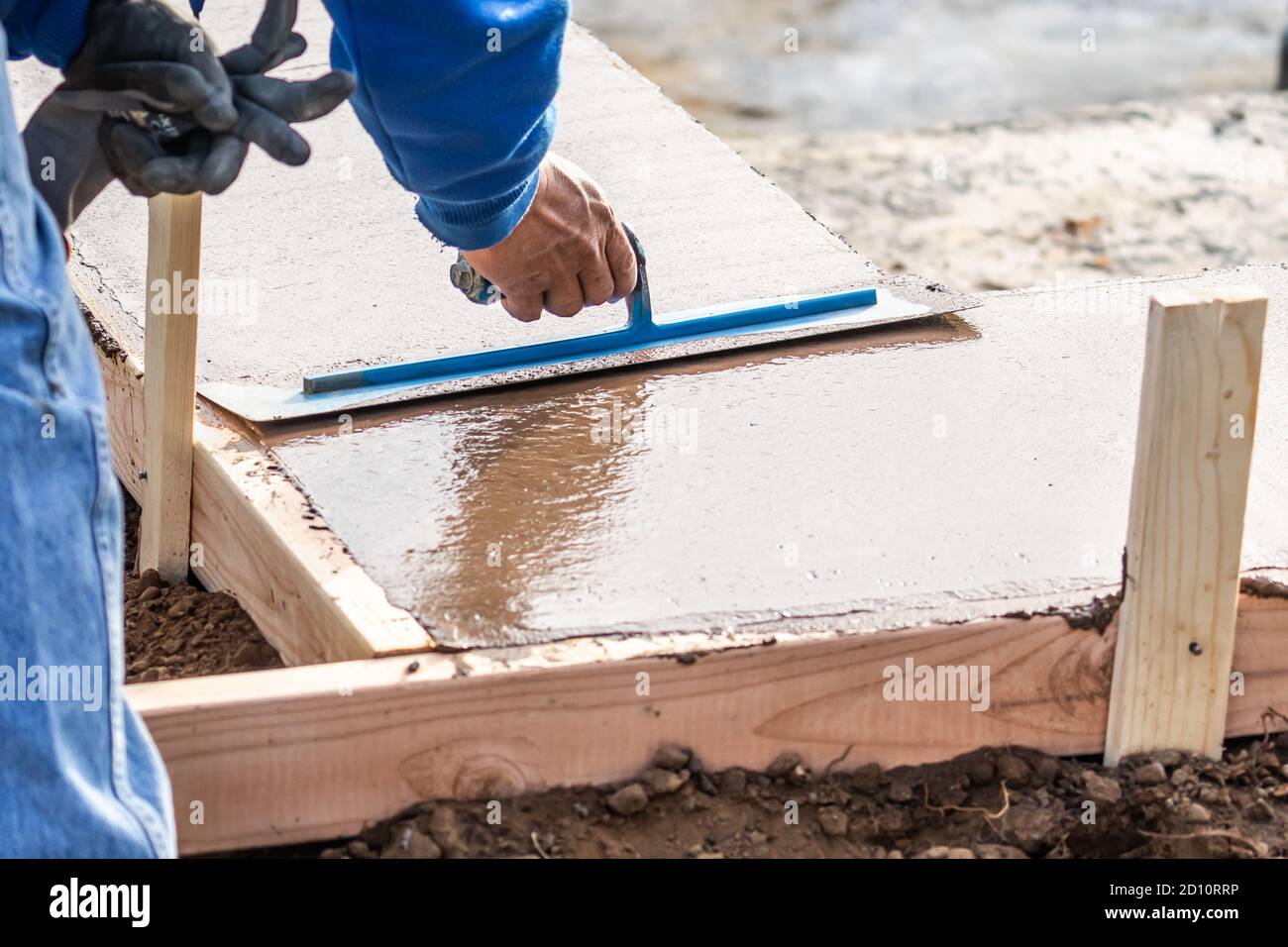 Construction Worker Using Trowel On Wet Cement Forming Coping Around ...