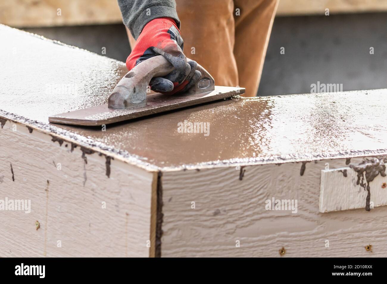 Construction Worker Using Wood Trowel On Wet Cement Forming Coping ...