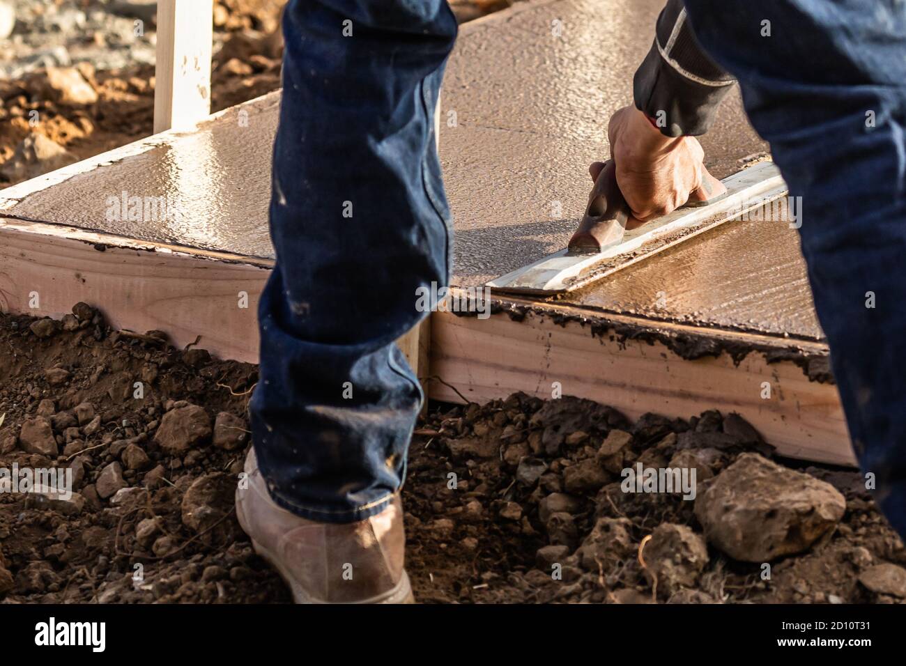 Construction Worker Using Wood Trowel On Wet Cement Forming Coping ...
