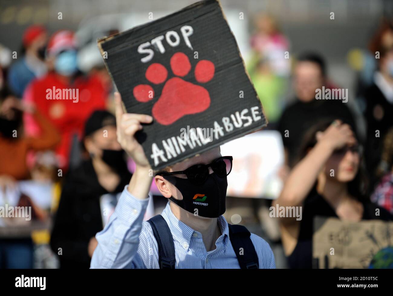 Activist holding a placard saying, stop animal abuse, during a rally ...