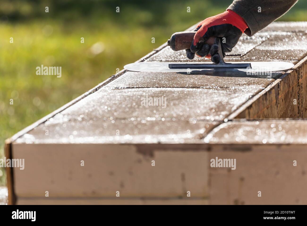 Construction Worker Using Trowel On Wet Cement Forming Coping Around ...