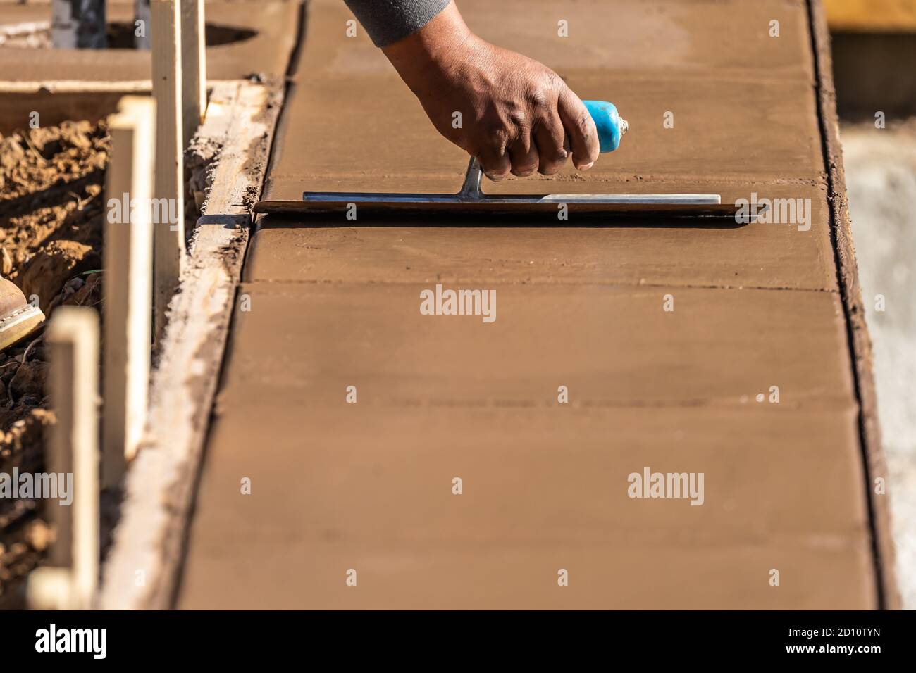 Construction Worker Using Trowel On Wet Cement Forming Coping Around ...
