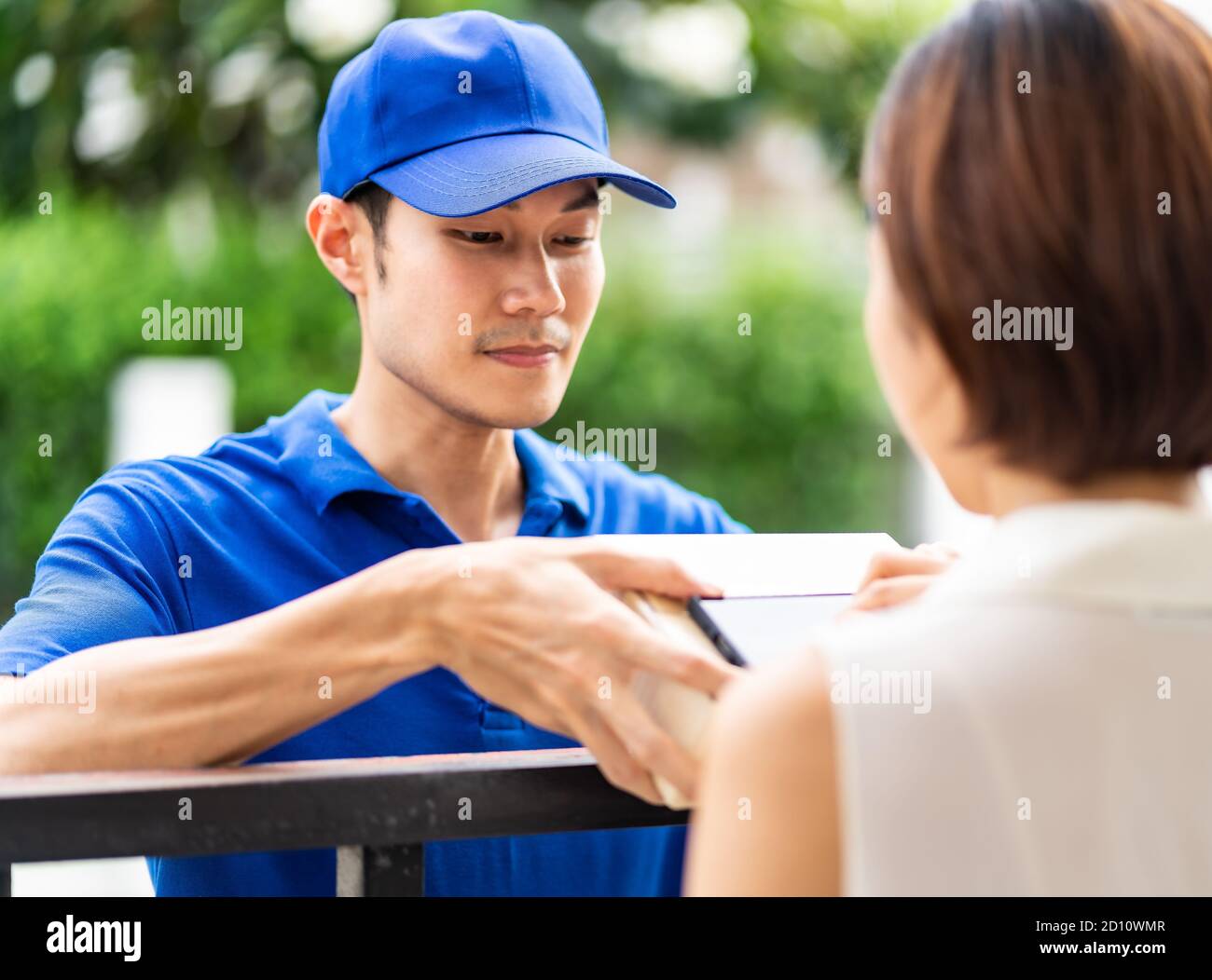 Asian woman sign electronic signature to portable mobile device after ...