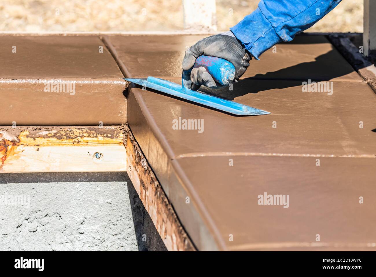 Construction Worker Using Trowel On Wet Cement Forming Coping Around ...