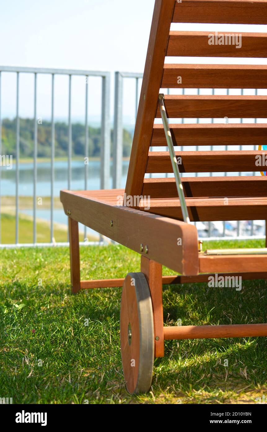 Close up of exterior wooden deck chair on lawn. View of beauriful ...