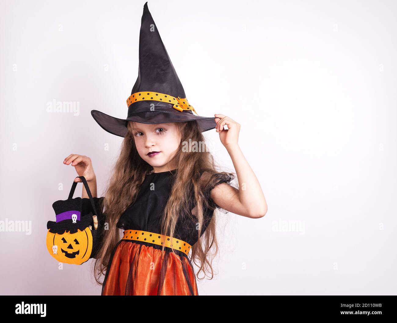 Happy laughing little girl wearing a witch carnival costume playing ...