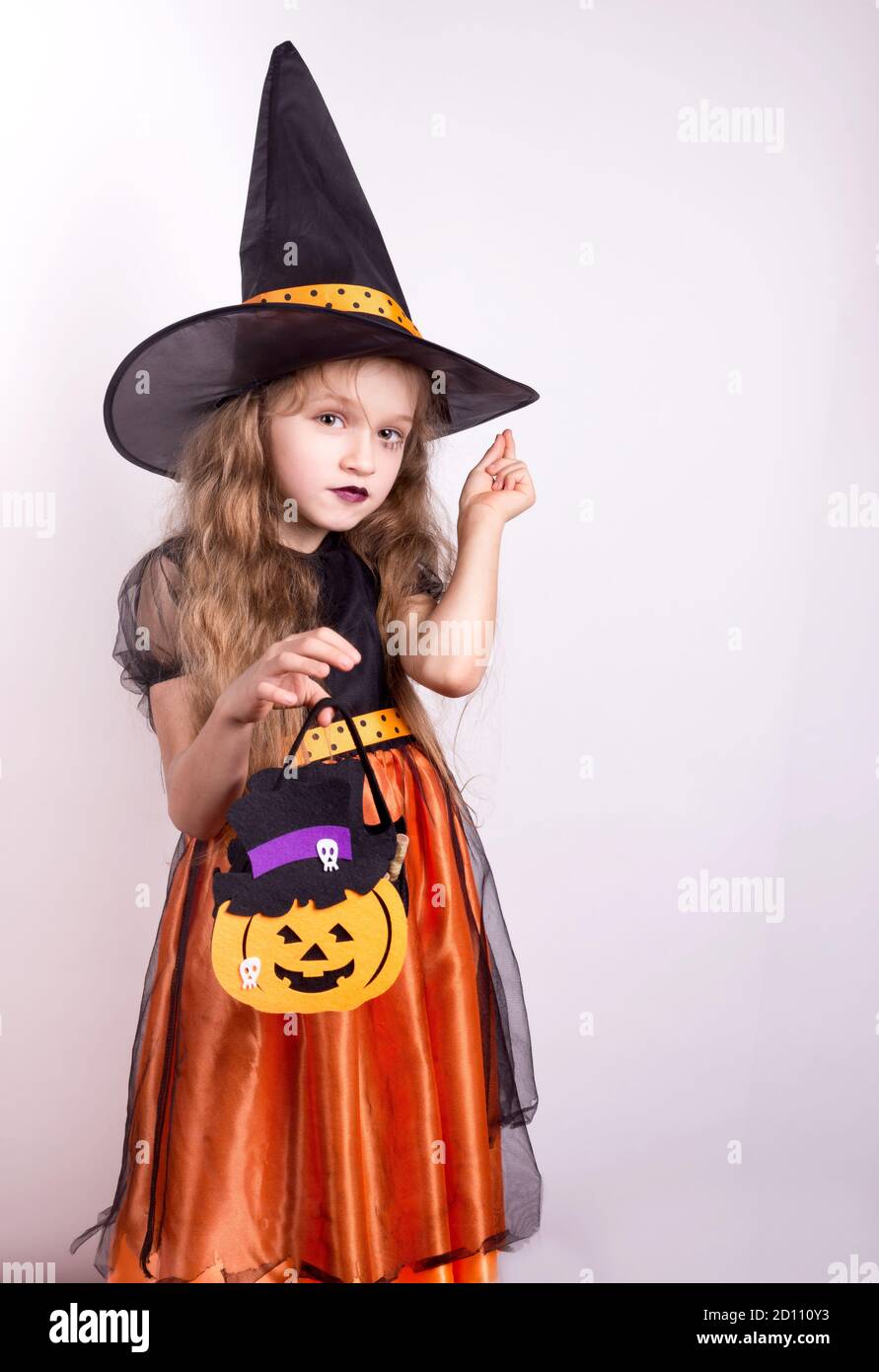Happy laughing little girl wearing a witch carnival costume playing ...
