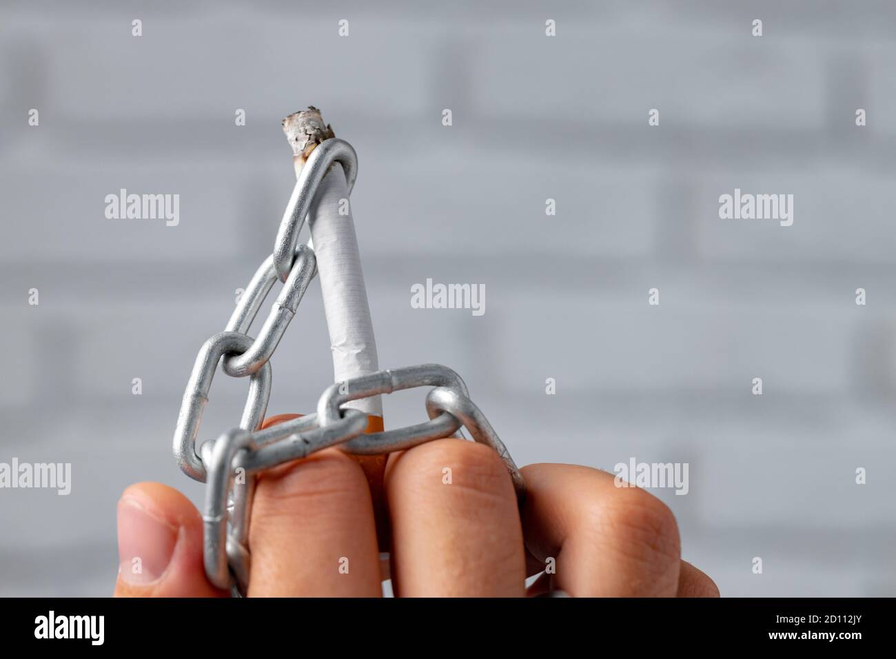 Male hand in metal chains holding cigarette Stock Photo - Alamy