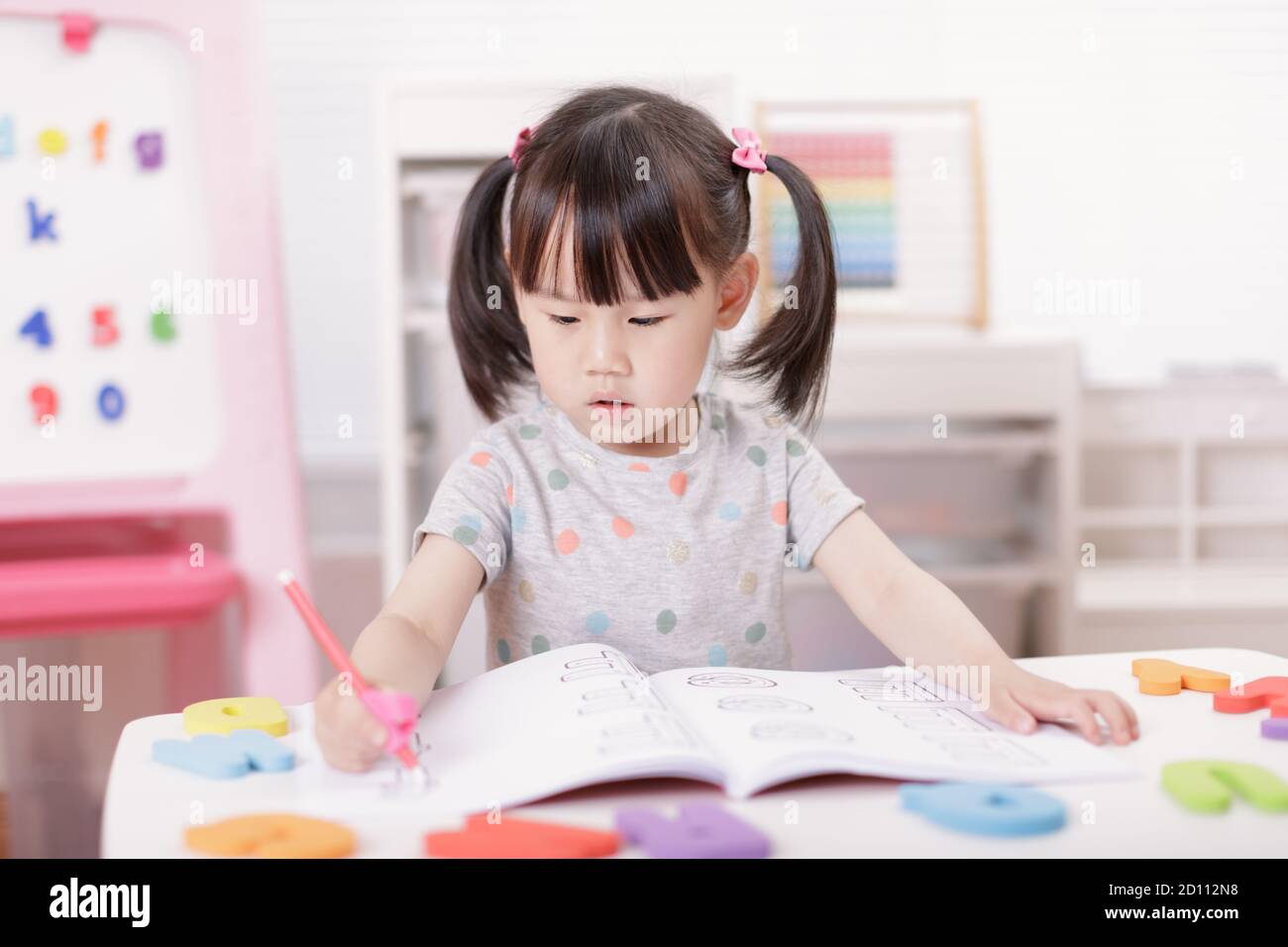 young girl practice writing letters for homeschooling Stock Photo - Alamy