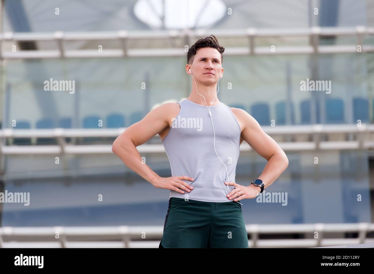Handsome fit man listening motivational music for workout outdoors ...