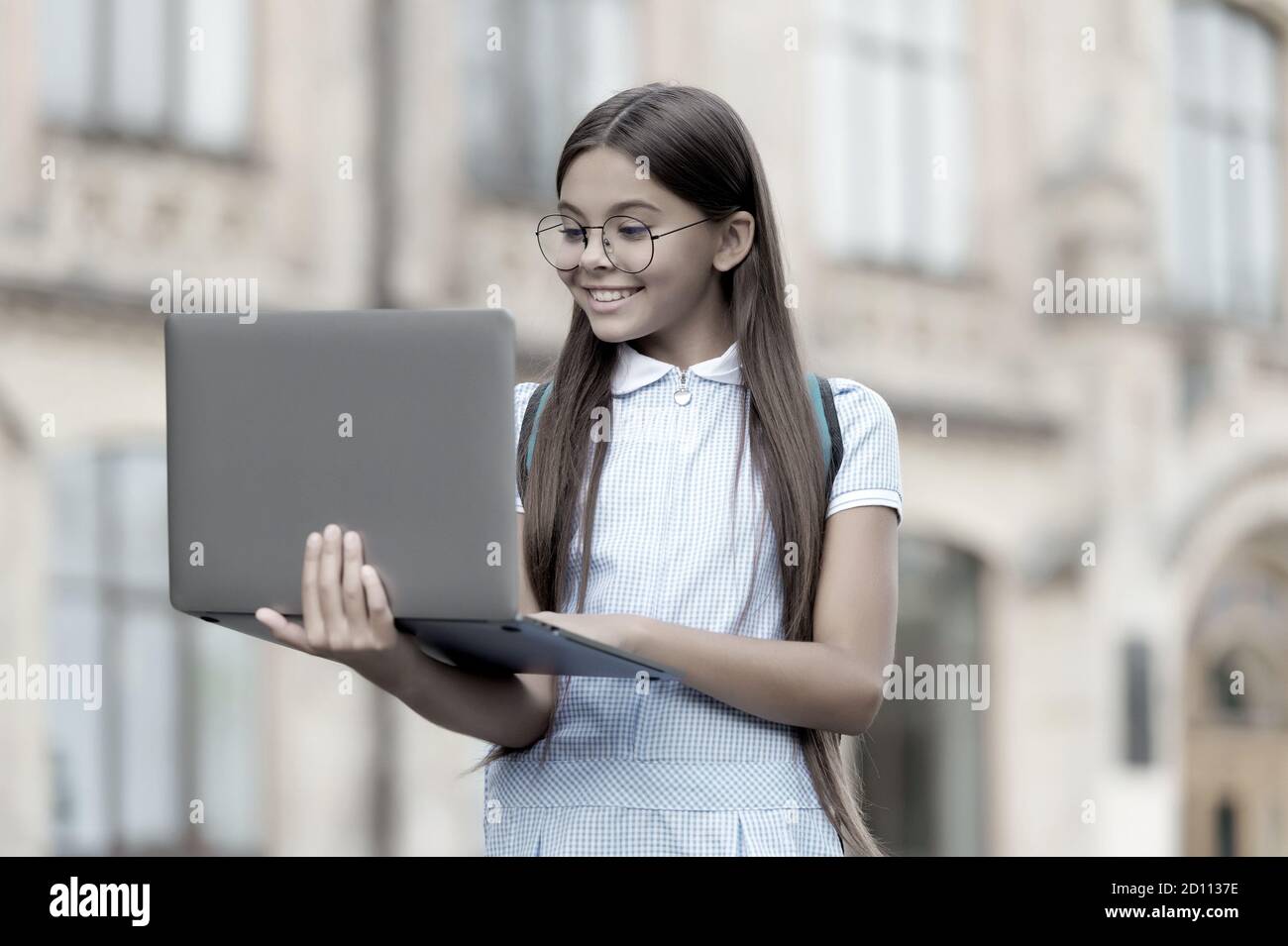smart looking kid in gasses typing on computer searching information in ...
