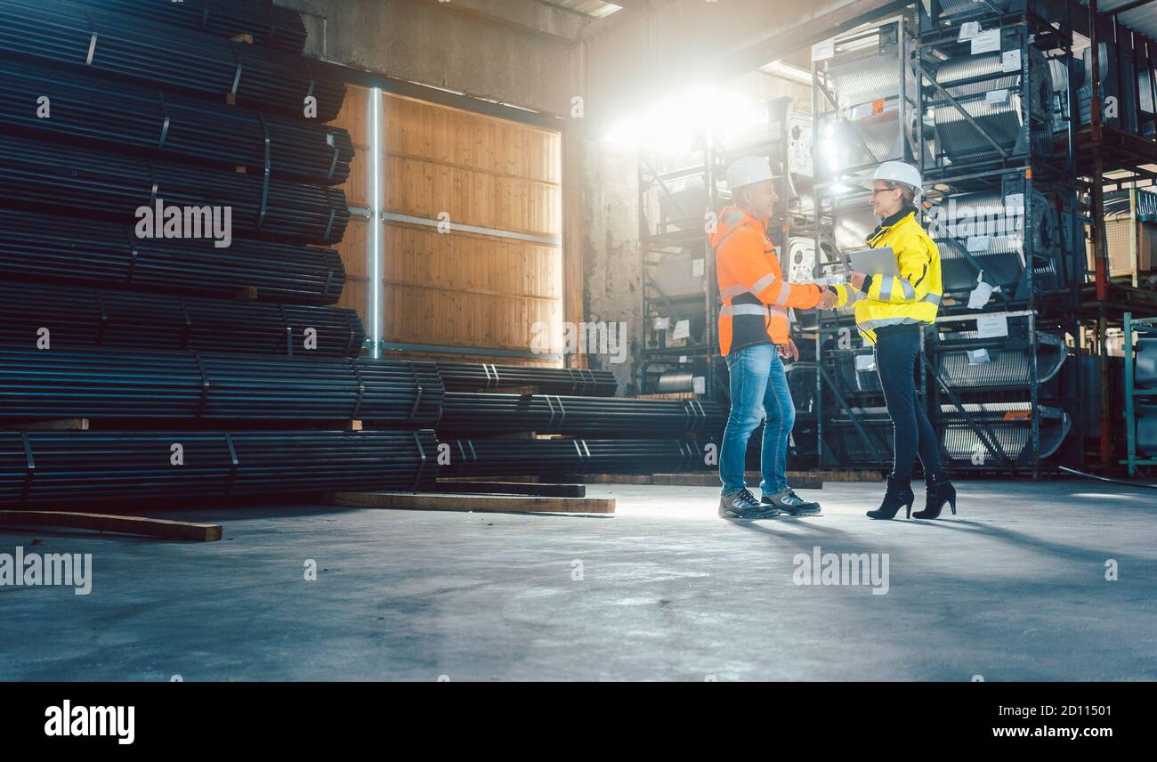 worker and customer in warehouse doing Handshake Stock Photo - Alamy