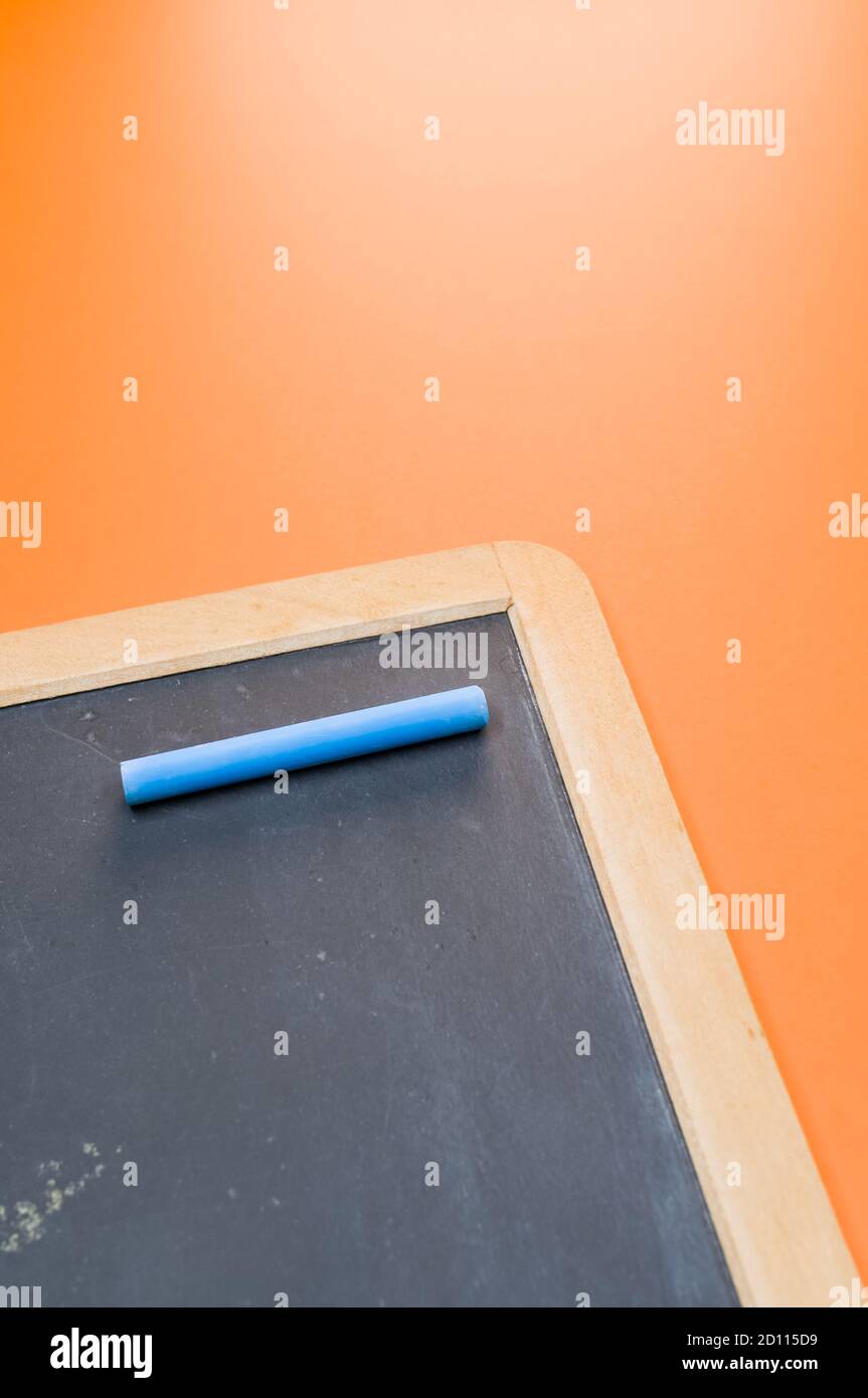 Vertical high angle shot of a blackboard with blue chalk on an orange ...