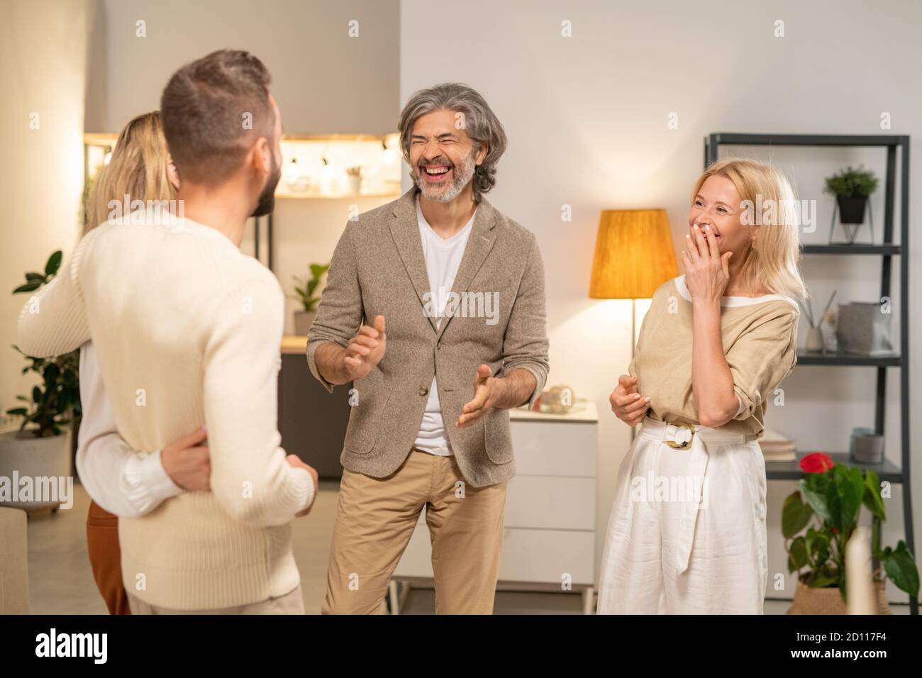 Joyful couples laughing while standing in front of one another in ...