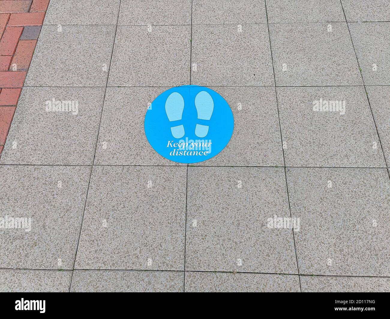 Keep your distance stand here sign on a pavement Stock Photo - Alamy