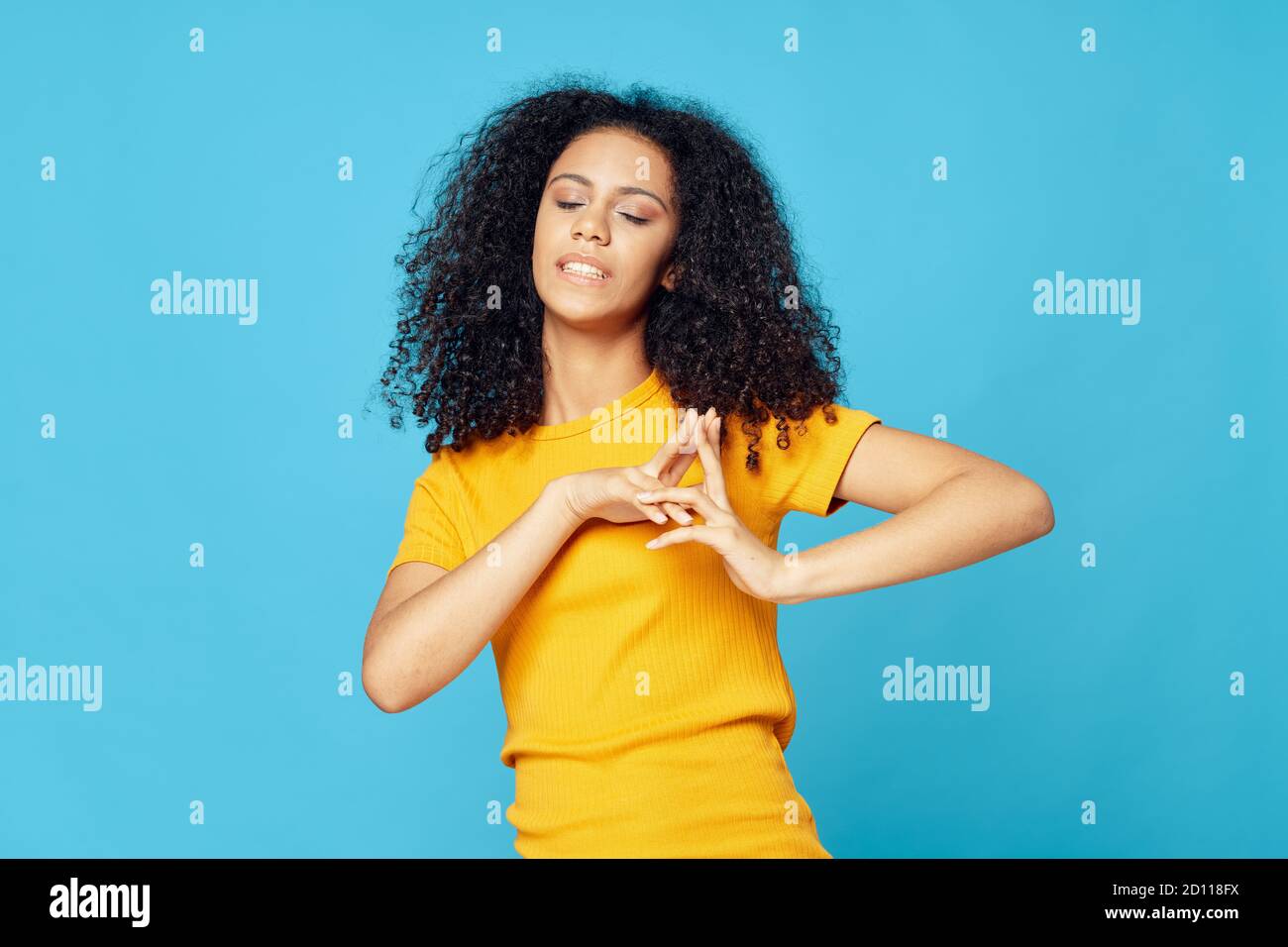 Charming woman with curly hair gesturing with hands Stock Photo - Alamy