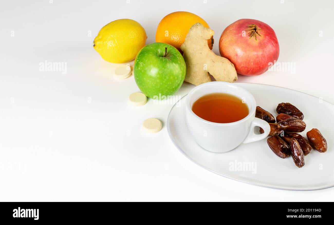 Fruit tea cup and dates on the white saucer, citrus tropical fresh ...