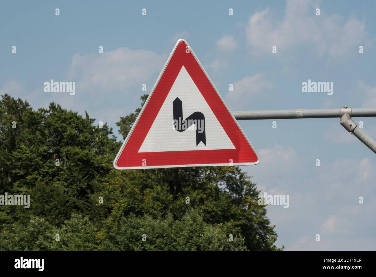 curve on the road and traffic sign as warning notice Stock Photo - Alamy