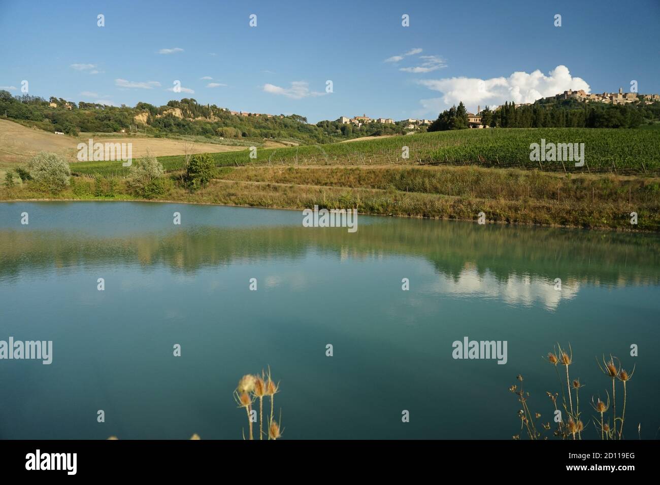 Small pond in front of distant village of Montepulciano, Tuscany Stock ...