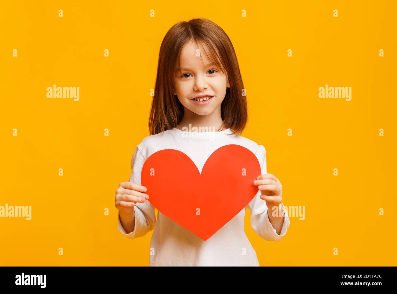 Smiling little girl with big red heart shaped card Stock Photo - Alamy