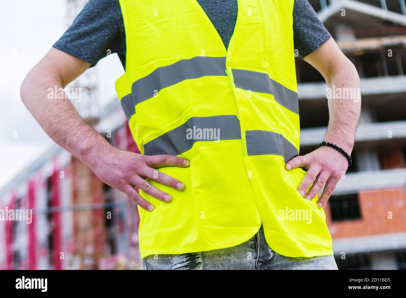 An engineer posing in front of building construction he is working of ...